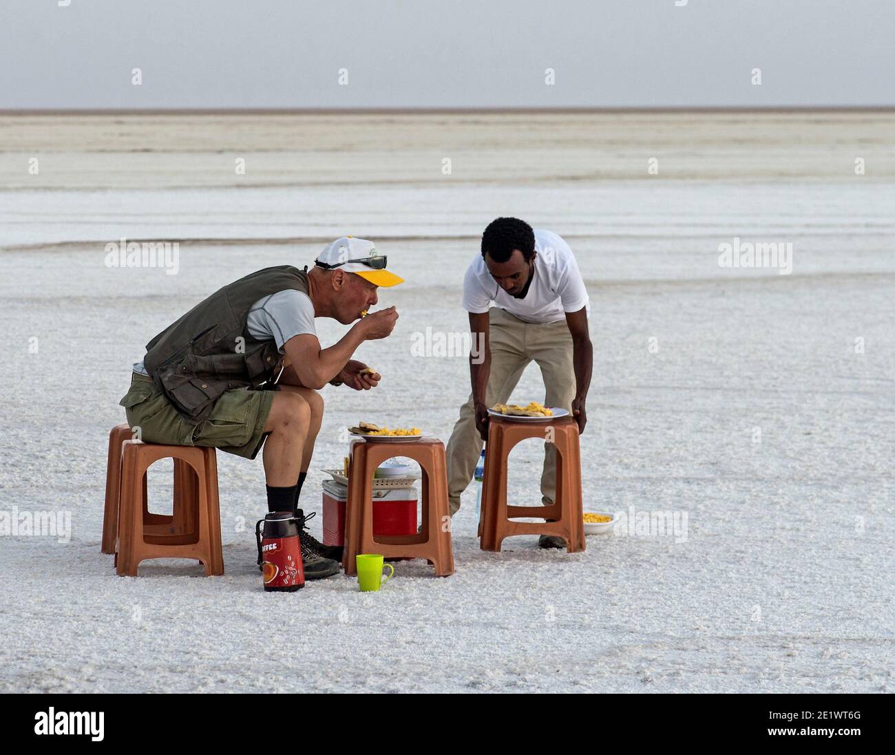 Tourist and local guide having a picnic on the Assale Salt Lake near ...