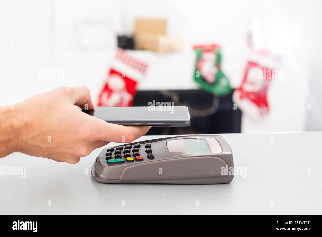 Customer using mobile phone to pay by NFC Stock Photo - Alamy