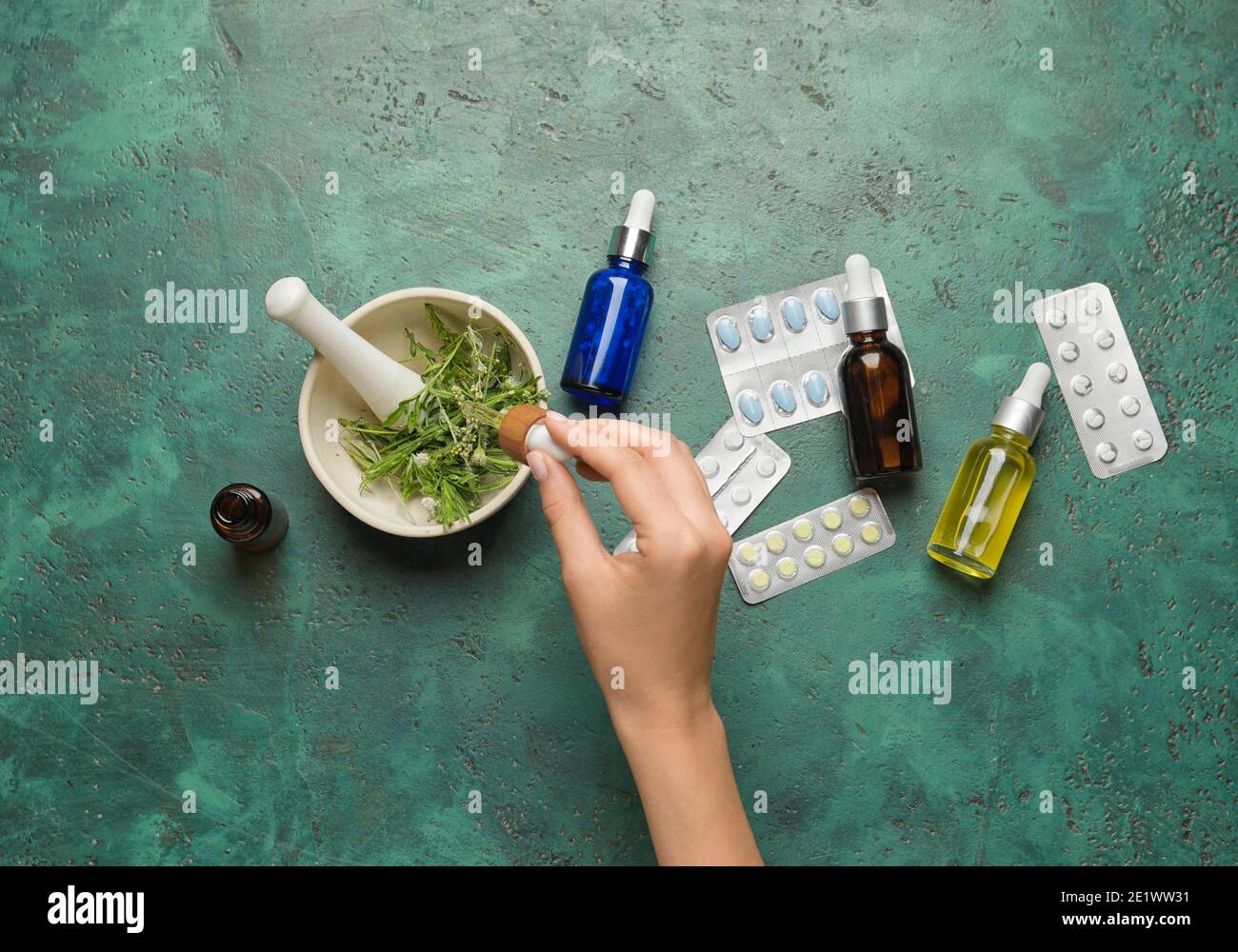 Woman making herbal based medicines on color background Stock Photo - Alamy