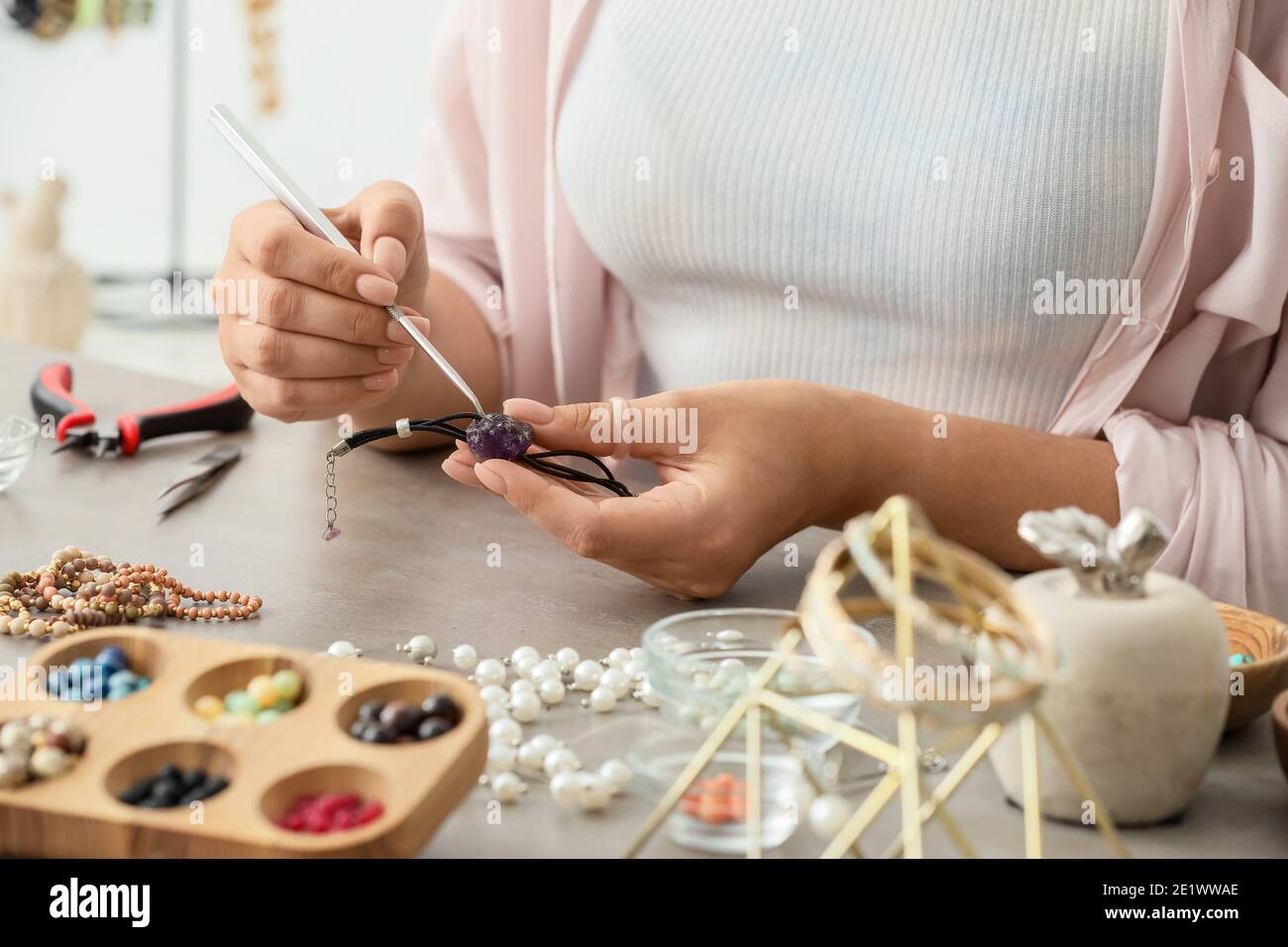 Female designer making jewelry at workplace Stock Photo - Alamy