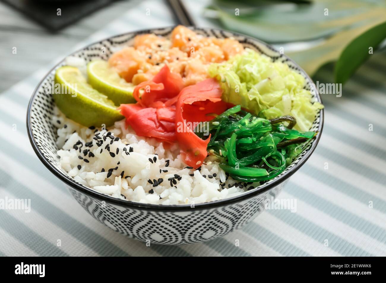 Bowl with tasty rice, fish and vegetables on color background Stock ...