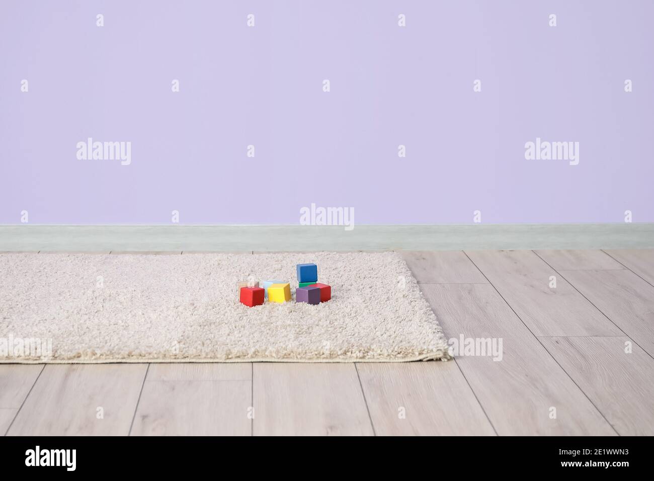 Cubes on soft carpet near color wall in room Stock Photo - Alamy