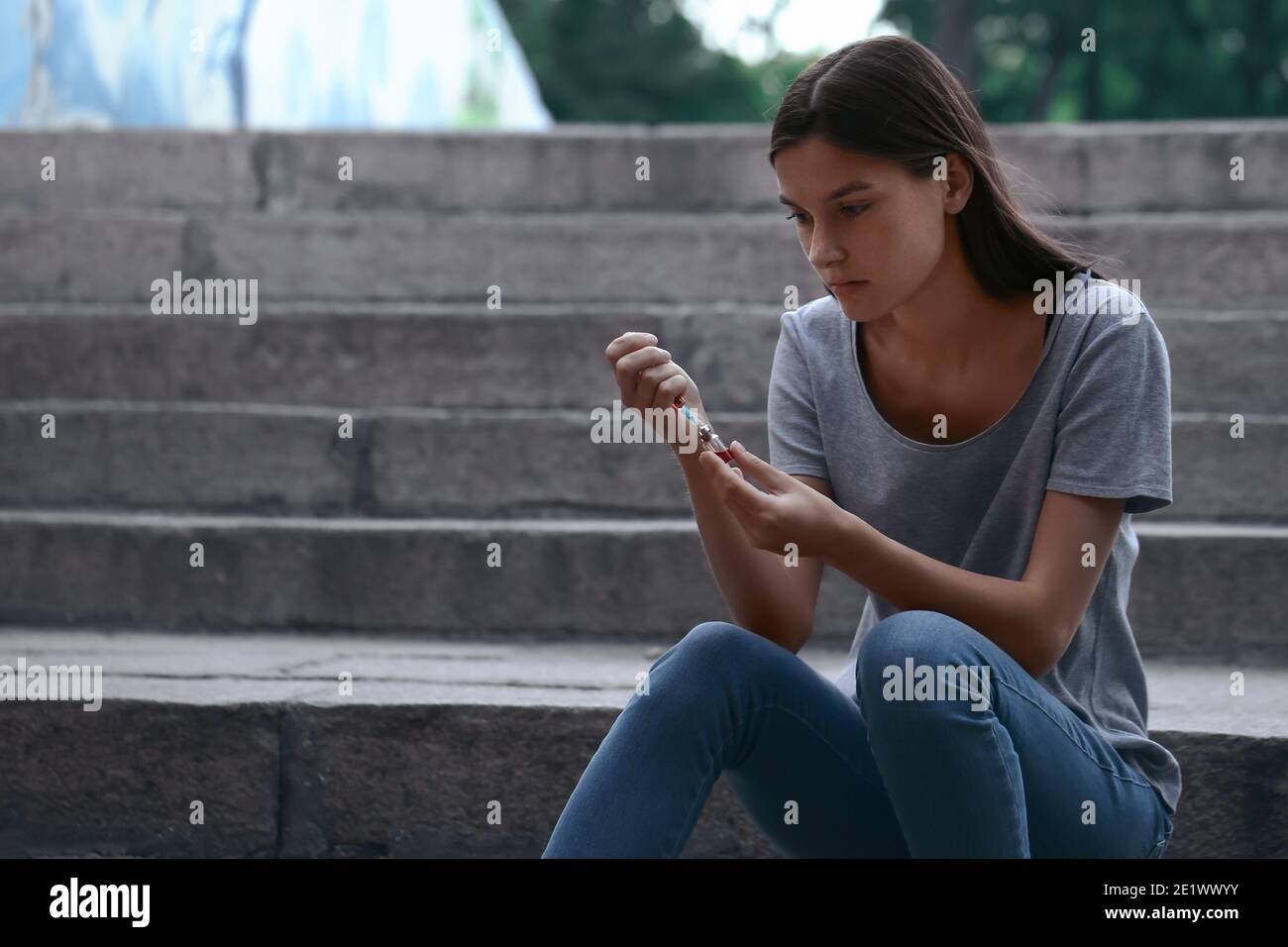 Female junkie giving herself injection outdoors Stock Photo - Alamy