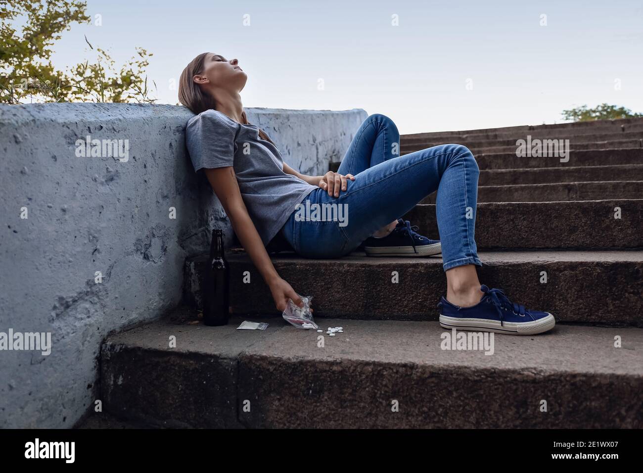Female junkie sitting on stairs outdoors Stock Photo - Alamy
