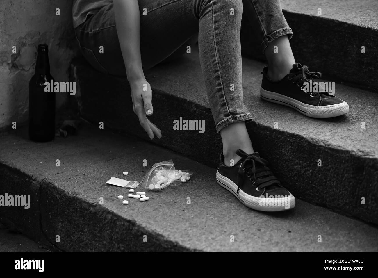 Female junkie sitting on stairs outdoors Stock Photo - Alamy