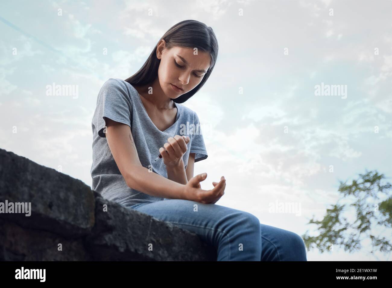 Female junkie giving herself injection of drugs outdoors Stock Photo ...