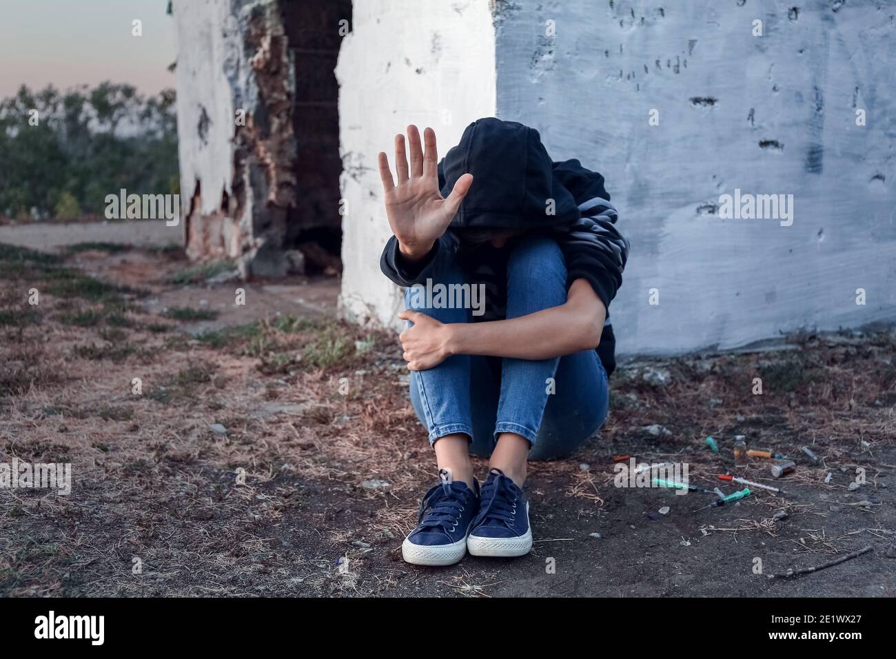 Female junkie showing STOP gesture outdoors Stock Photo - Alamy