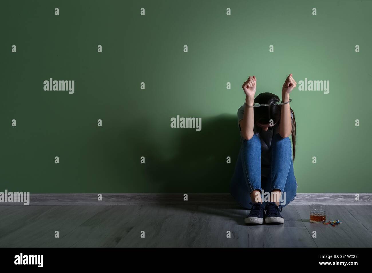Female junkie with drugs and alcohol near color wall Stock Photo - Alamy