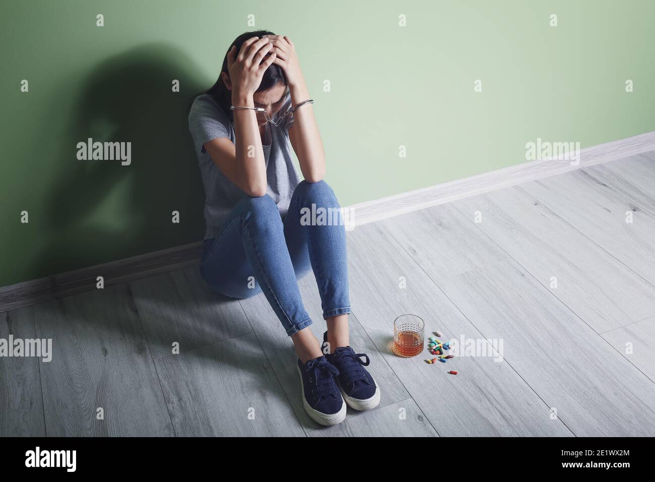 Female junkie with drugs and alcohol near color wall Stock Photo - Alamy