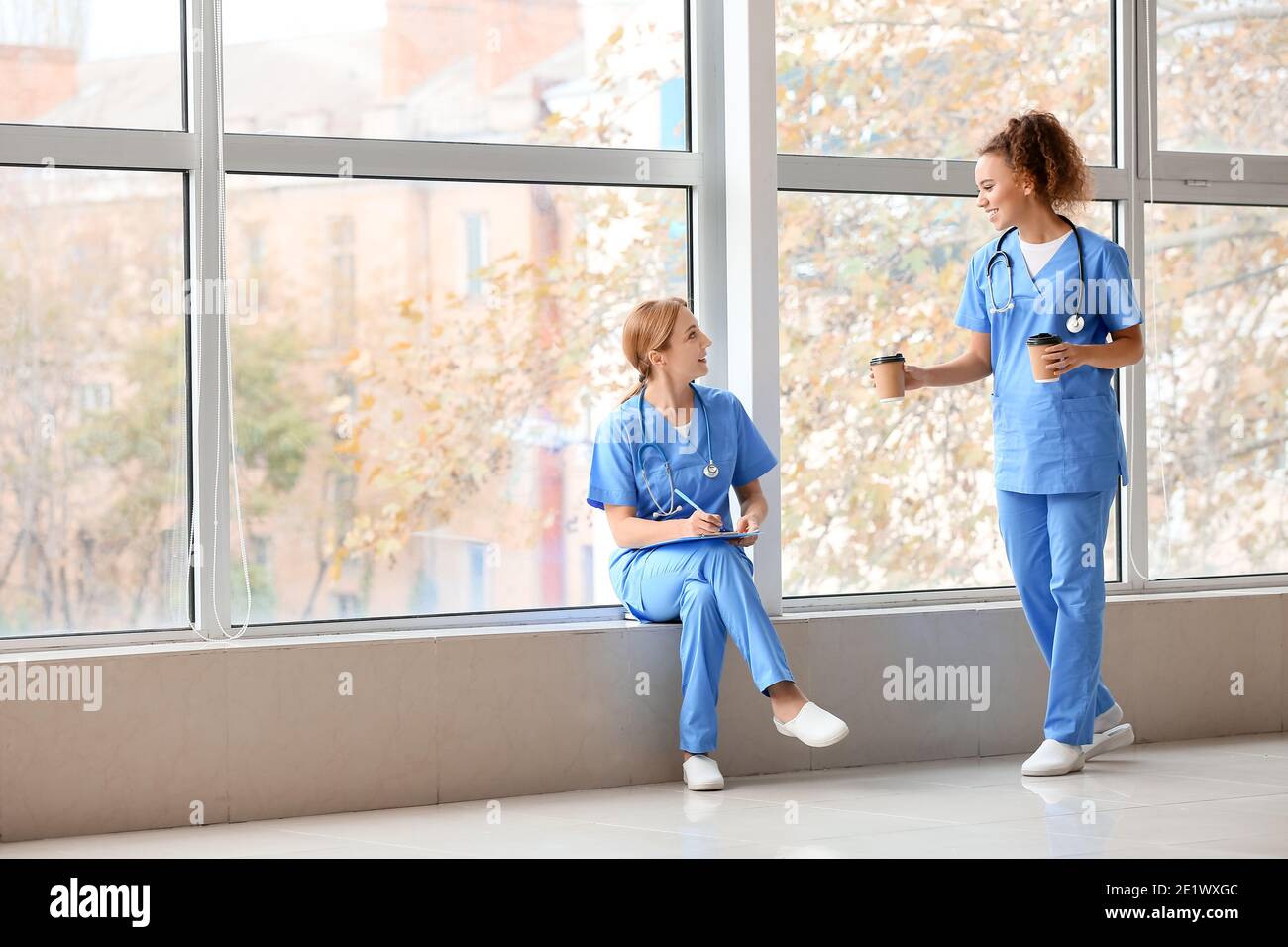 Female doctors drinking coffee in clinic Stock Photo - Alamy