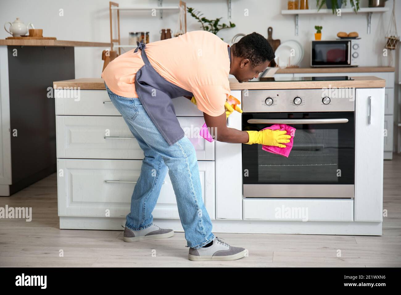 African-American man cleaning oven in kitchen Stock Photo - Alamy