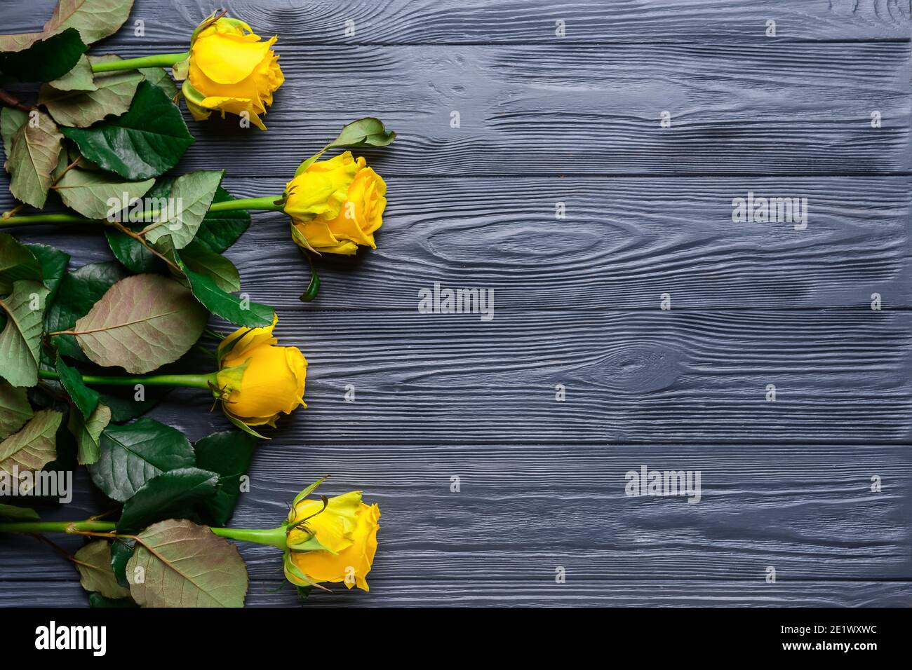 Beautiful yellow roses on wooden background Stock Photo - Alamy