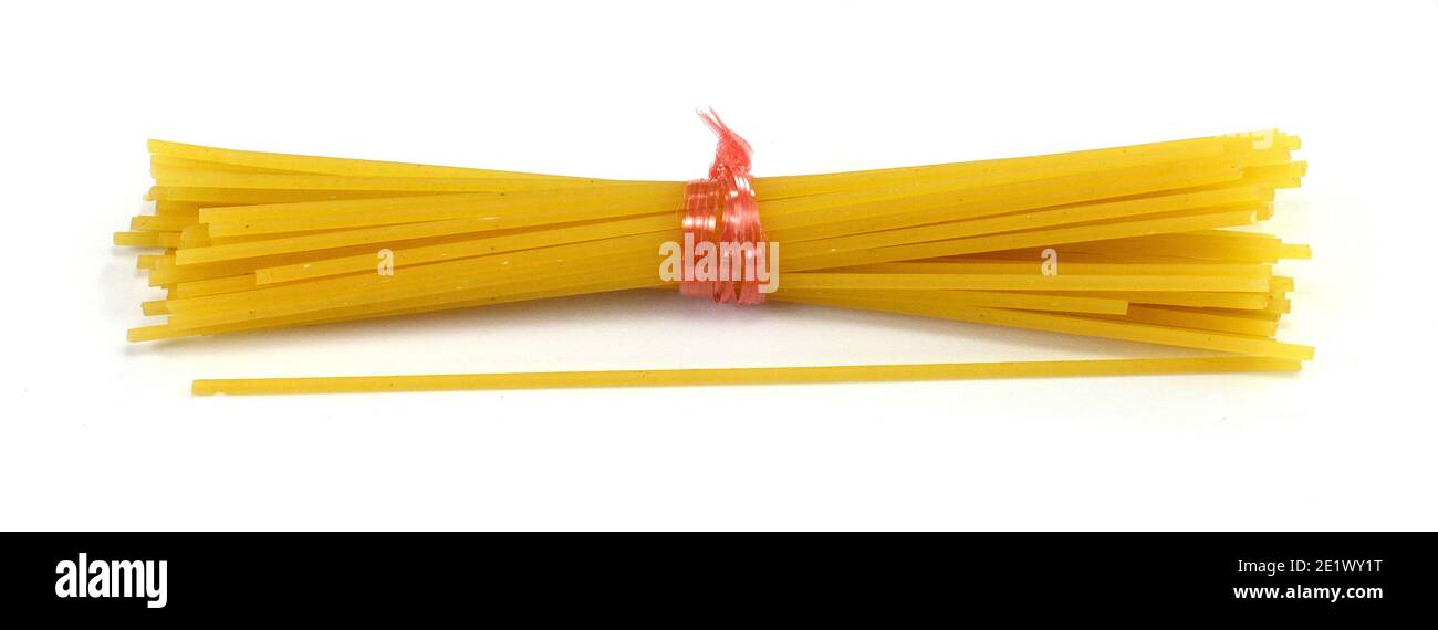 Uncooked dry fettuccine pasta tied in a bundle isolated on a white ...