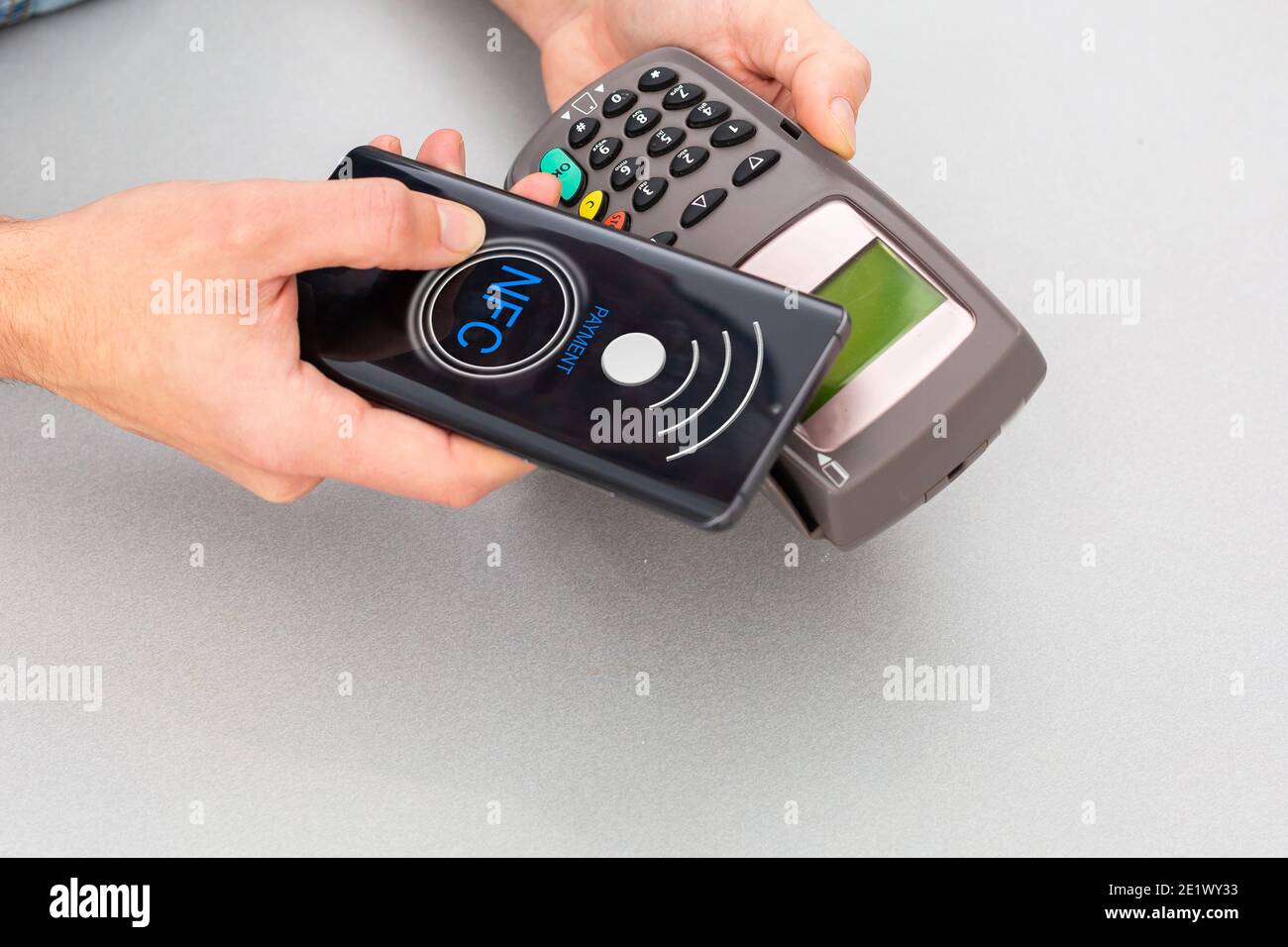 Customer using mobile phone to pay by NFC Stock Photo - Alamy