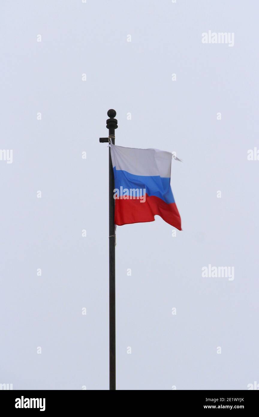 Russian flag on a light sky background. White, blue and red tricolor ...