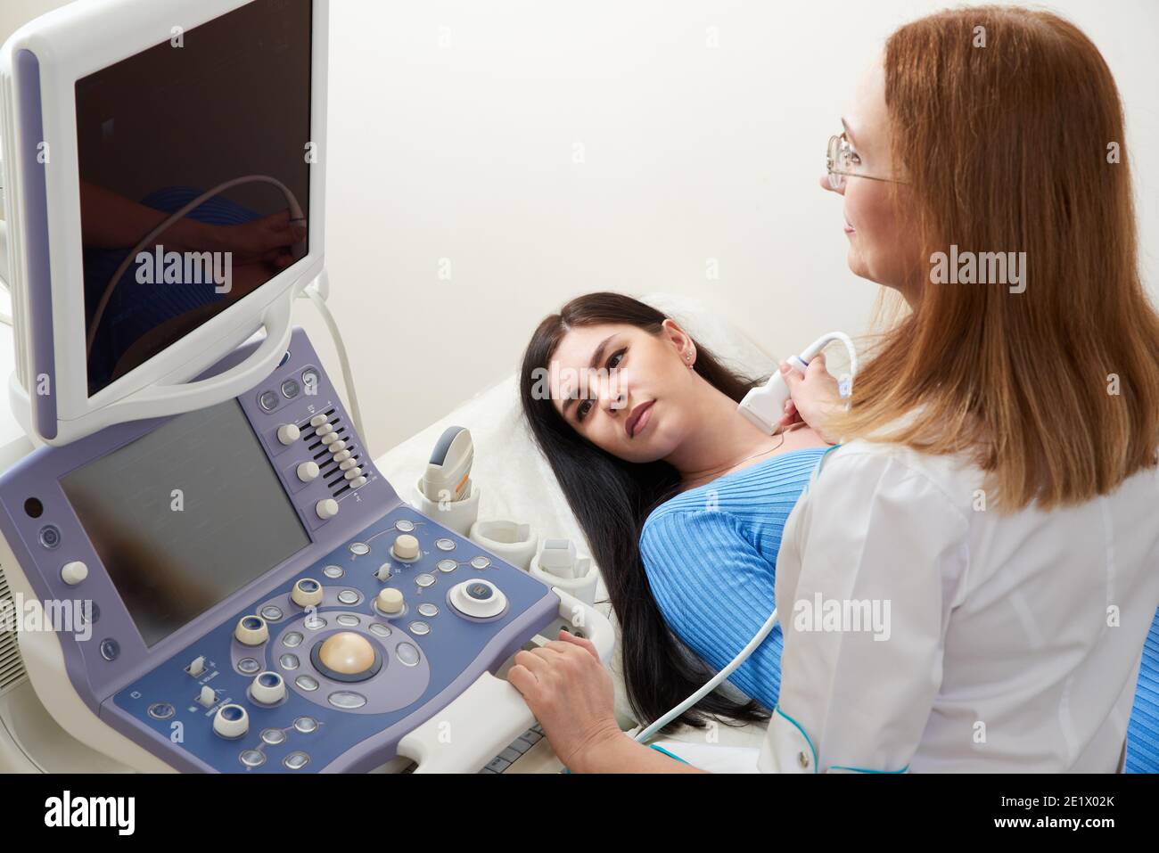 Doctor Using Ultrasound Scanning Machine Examining Female Neck Stock