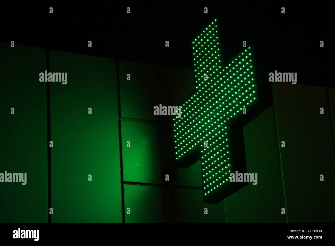 Glowing pixel cross of LED lamps on black background. Green cross ...