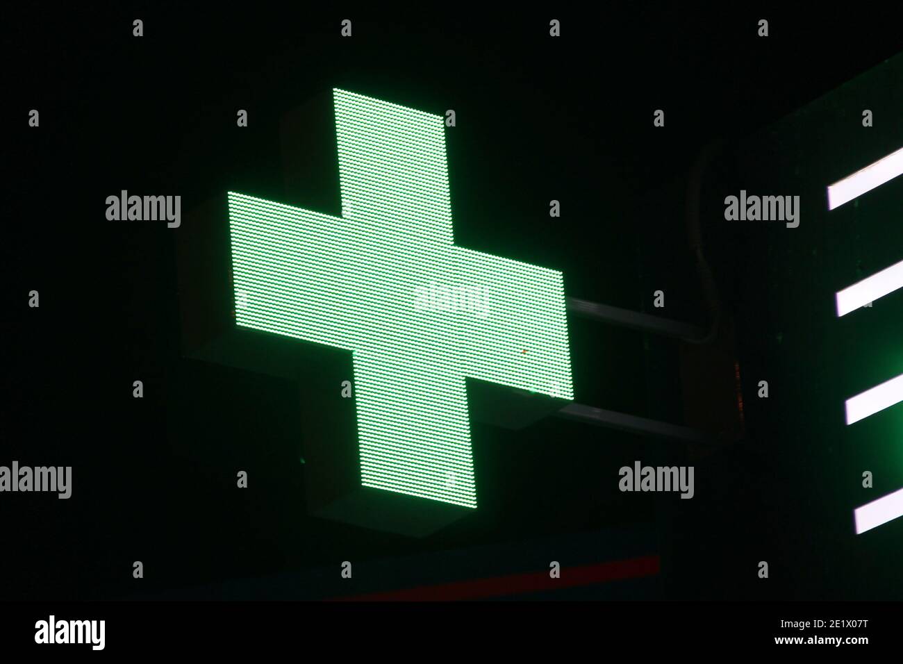 Glowing pixel cross of LED lamps on black background. Green cross ...