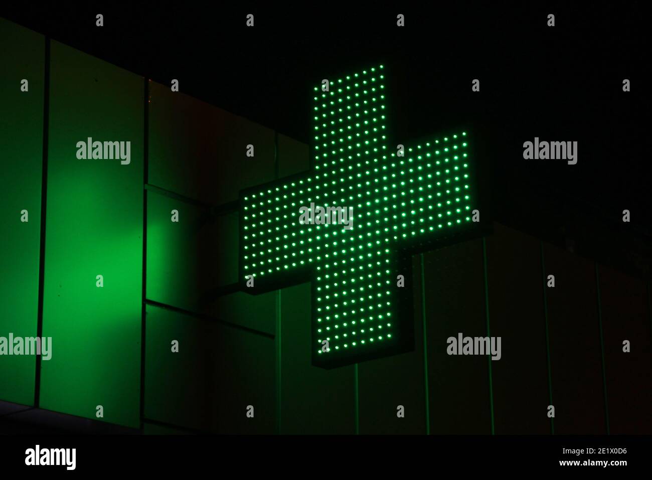 Glowing pixel cross of LED lamps on black background. Green cross ...