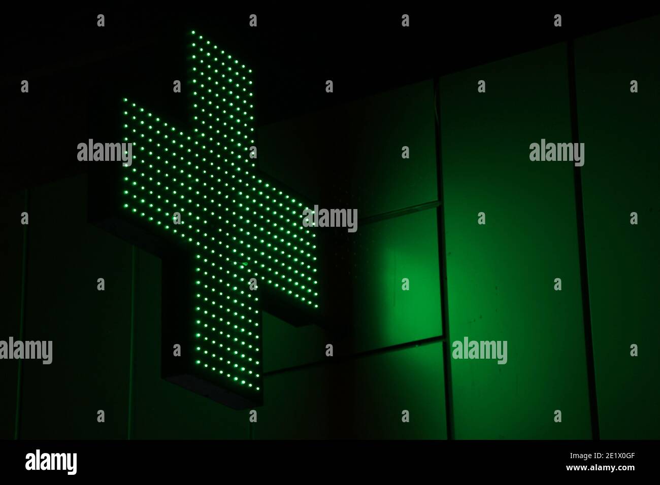 Glowing pixel cross of LED lamps on black background. Green cross ...
