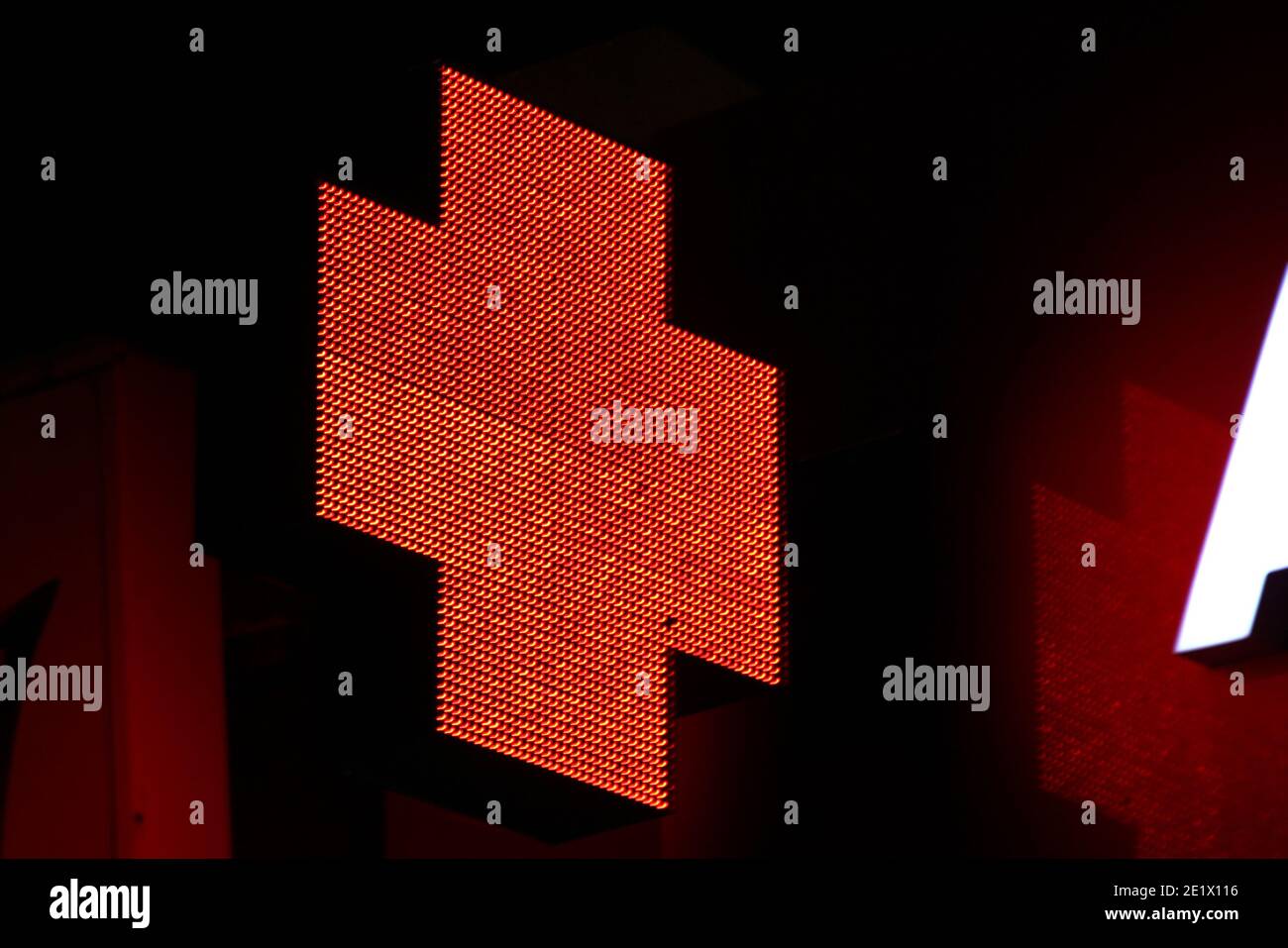 Glowing pixel cross of LED lamps on black background. Red cross symbol ...