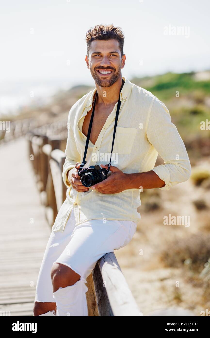 Smiling man photographing in a coastal area Stock Photo - Alamy