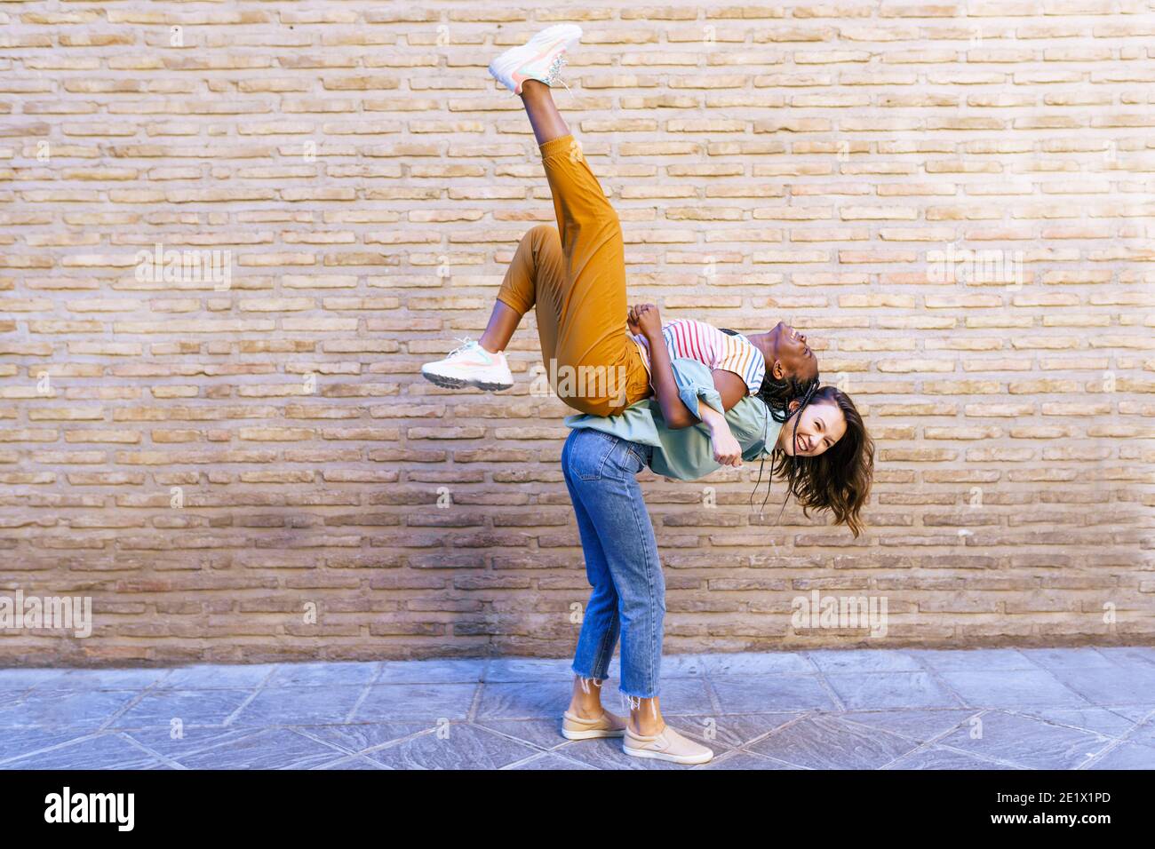 Funny multiethnic woman carrying her best friend piggyback Stock Photo ...