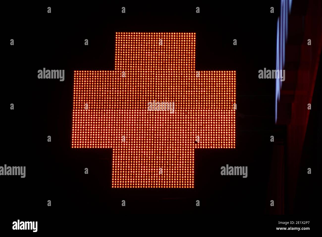 Glowing pixel cross of LED lamps on black background. Red cross symbol ...
