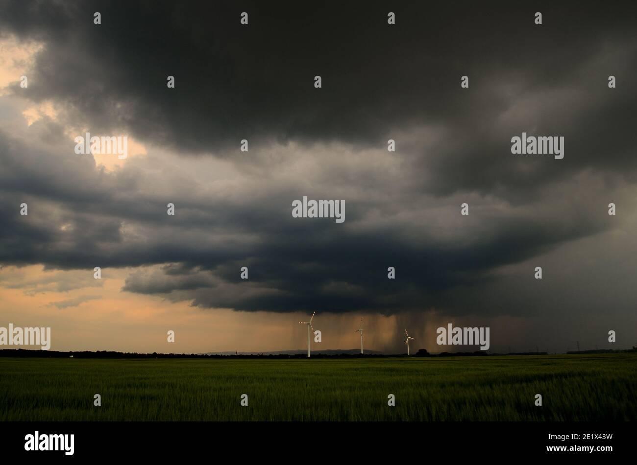 three windmills with black clouds and rain Stock Photo - Alamy
