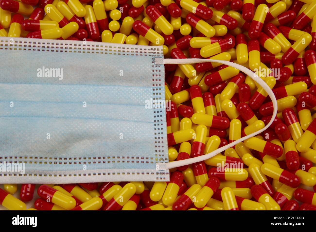 Close up of surgical face protection mask on pile red yellow drug ...