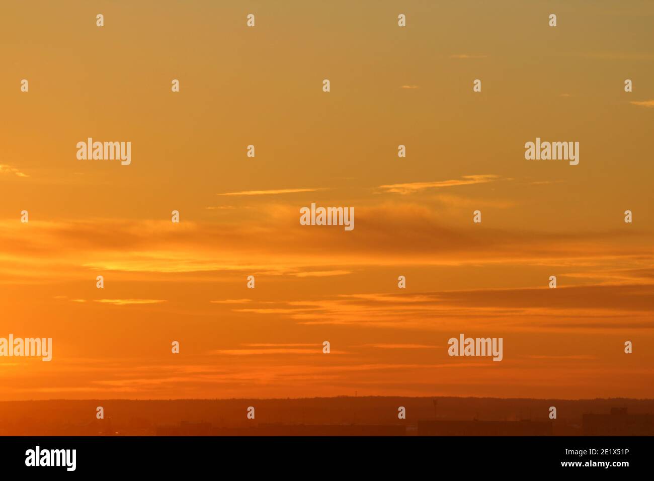 Sun below the horizon and clouds in the fiery dramatic orange sky at ...