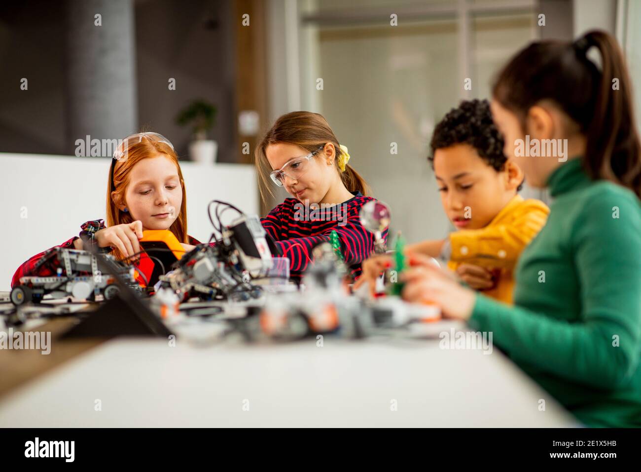 Group of happy kids programming electric toys and robots at robotics ...
