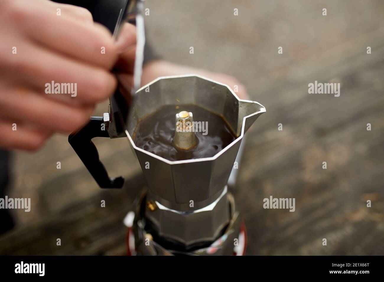 Traveler man making coffee outdoor with metal geyser coffee maker on a ...