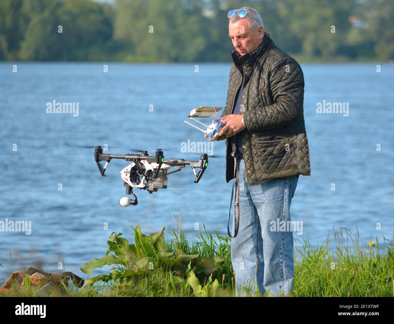 Man flying Drone, Drone in picture, water in background Stock Photo - Alamy