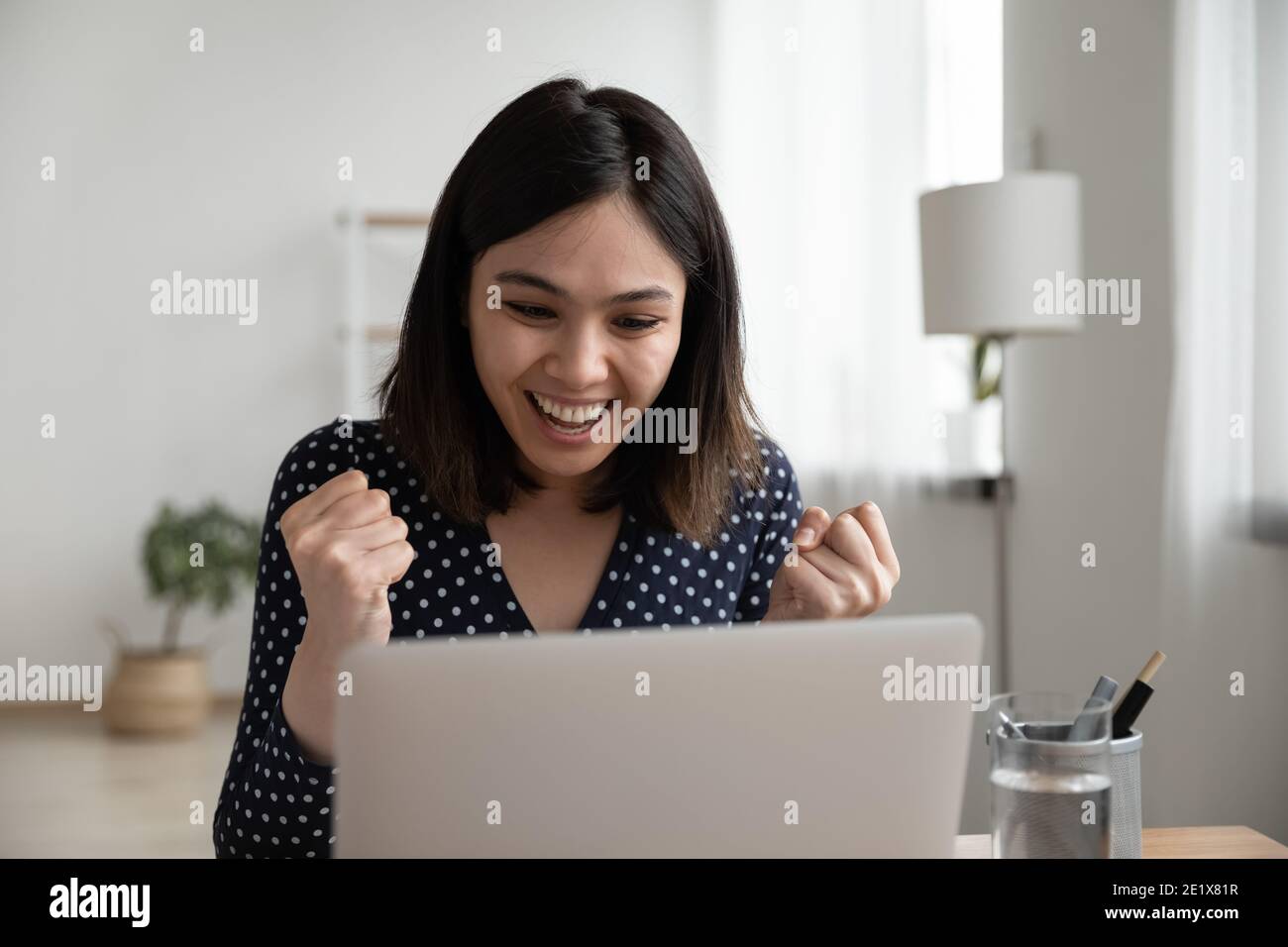 Euphoric young asian woman reading email with amazing news Stock Photo ...