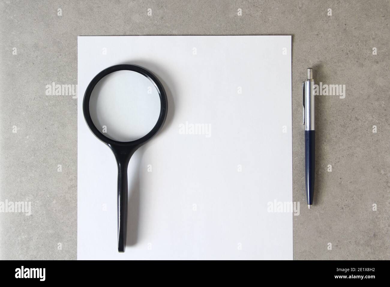 Template of white paper with a ballpoint pen, magnifying glass and on ...