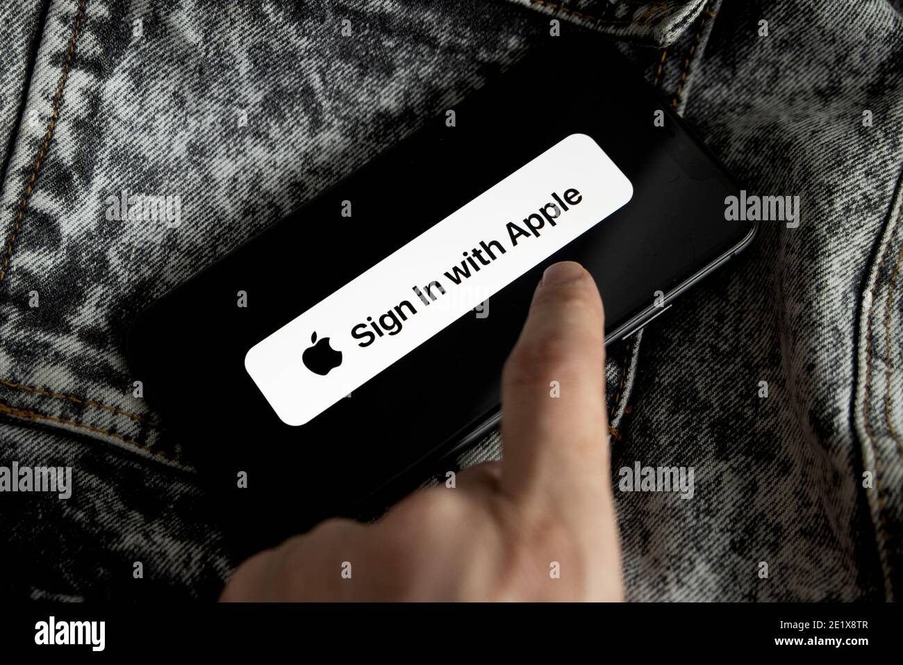 Apple ID logo on iPhone 11 screen with black and white denim background ...