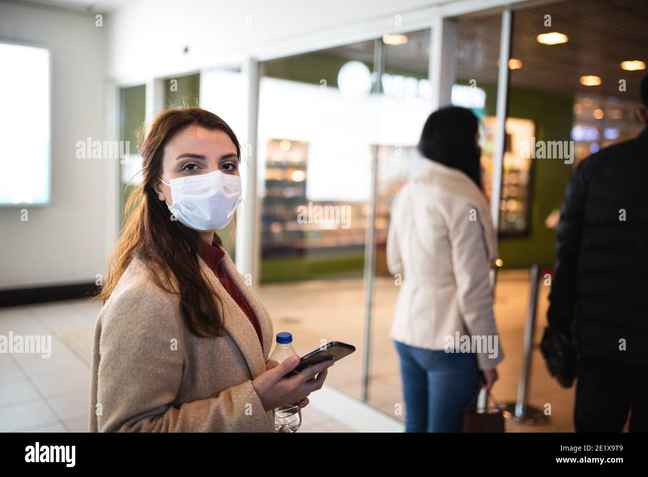 Beautiful woman wearing protective medical mask and fashionable clothes ...