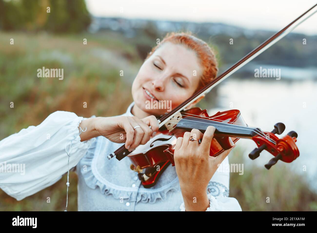 beautiful girl playing violin in white dress in forest Stock Photo - Alamy