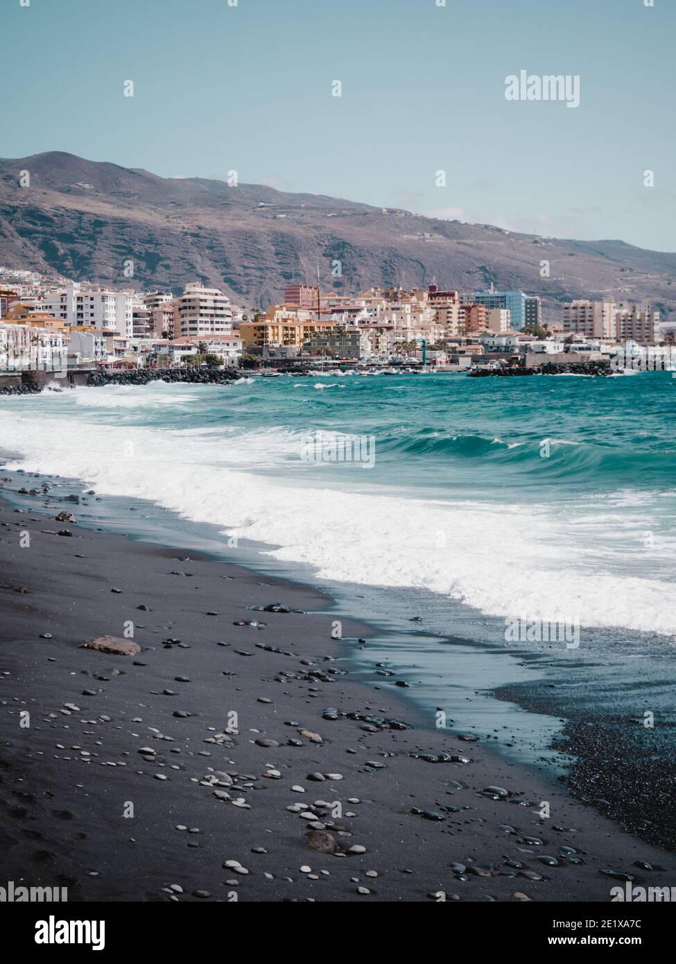 Volcanic beach by the city Stock Photo - Alamy