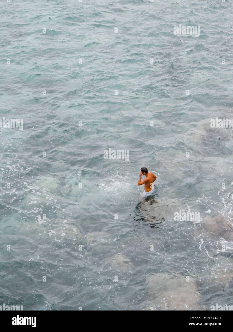 A man going for a swim in the ocean Stock Photo - Alamy
