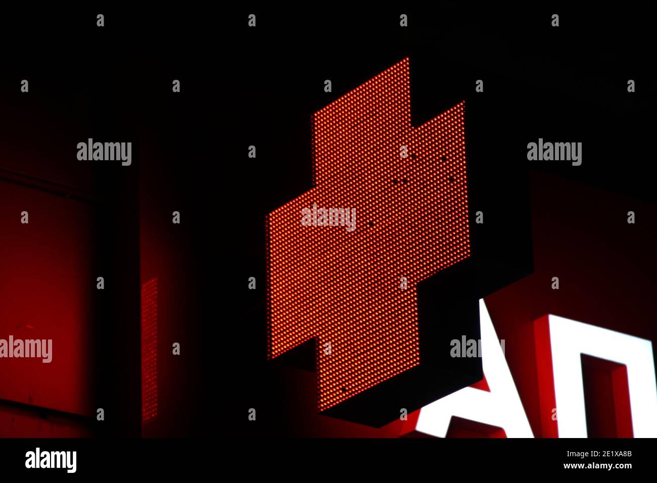 Glowing pixel cross of LED lamps on black background. Red cross symbol ...