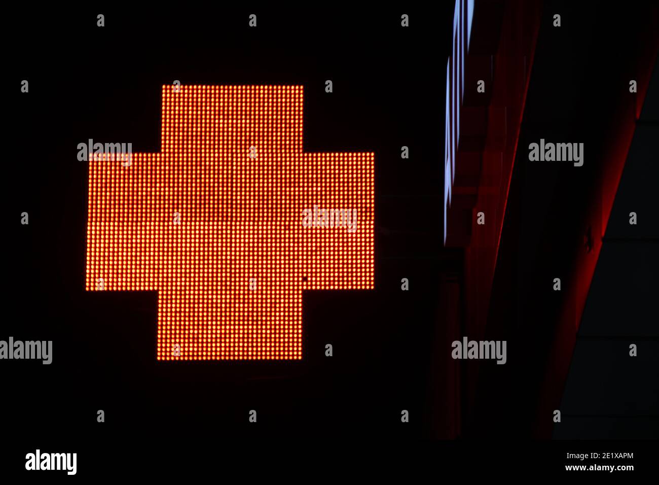 Glowing pixel cross of LED lamps on black background. Red cross symbol ...