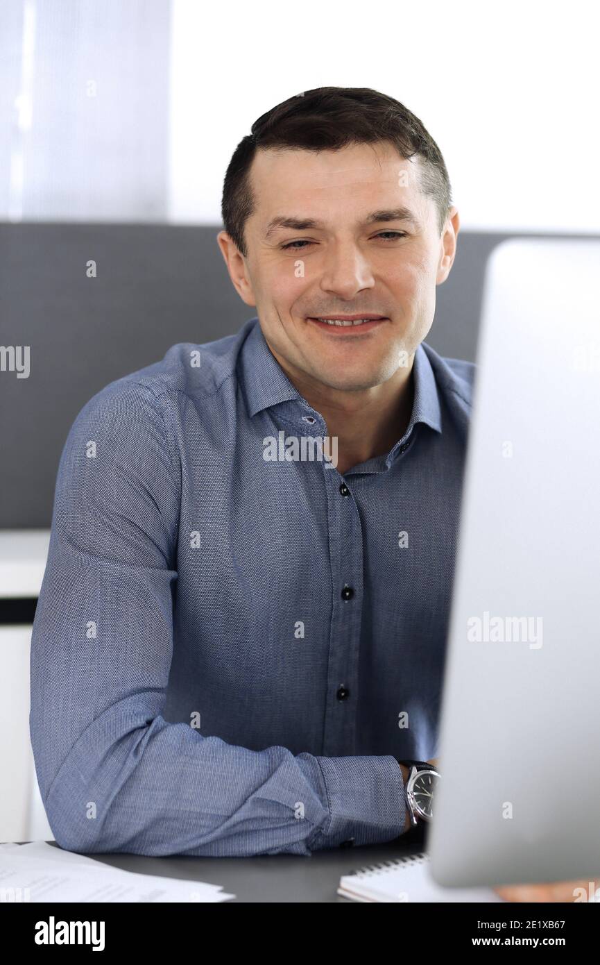 Businessman working with computer in modern office. Headshot of male ...