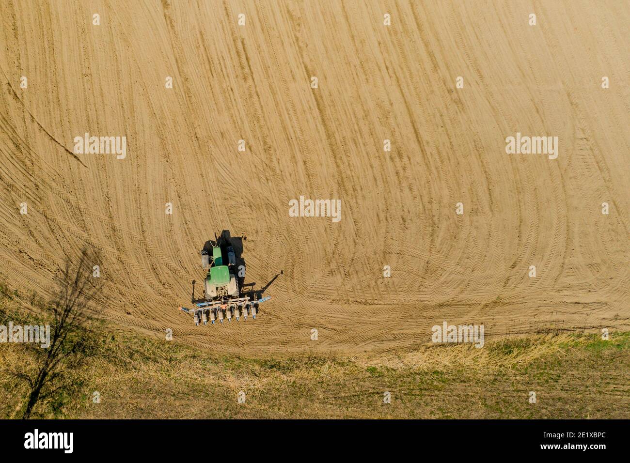 Aerial view large tractor cultivating a dry field. Top down aerial view ...