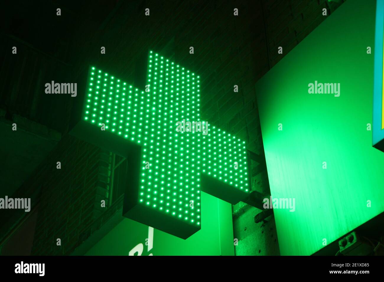 Glowing pixel cross of LED lamps on black background. Green cross ...