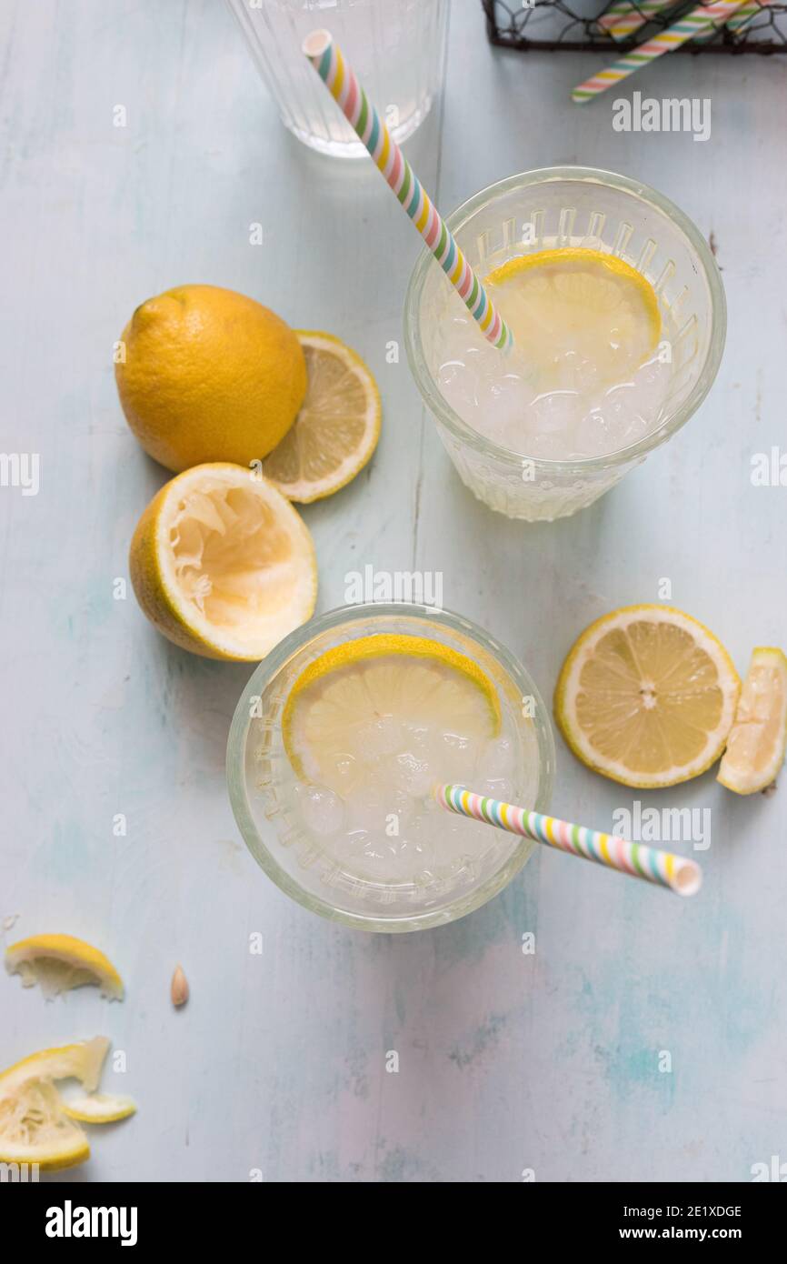 Overhead view of two lemonade glasses with two colorful straws inside ...