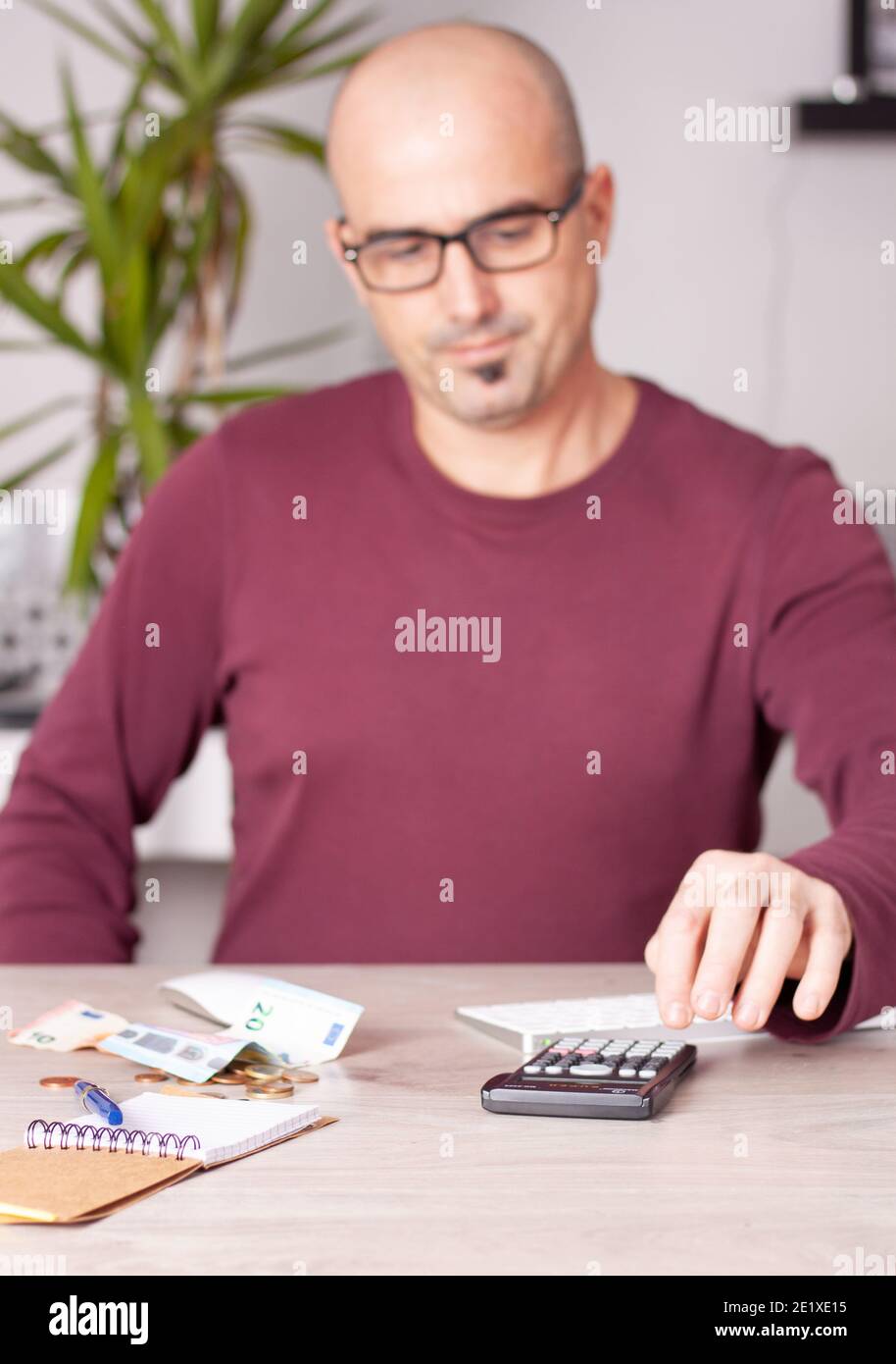 Man doing economic calculations at office table with a calculator Stock ...