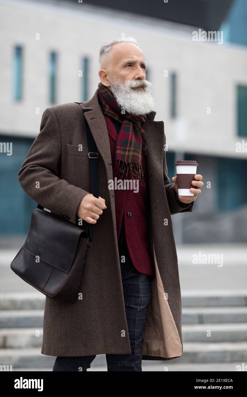 Stylish elderly man going to office, drinking coffee Stock Photo - Alamy