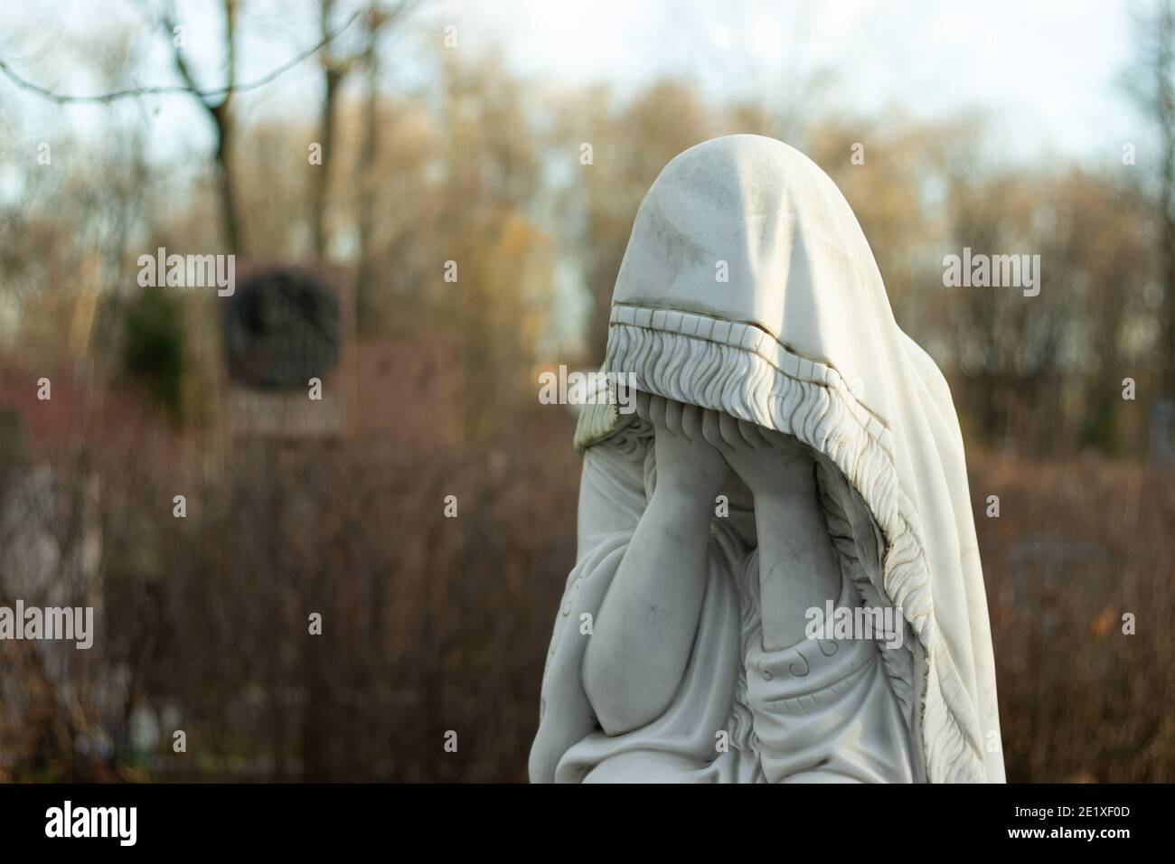 Marble sculpture of a grieving woman in a cemetery. Concept of loss of ...